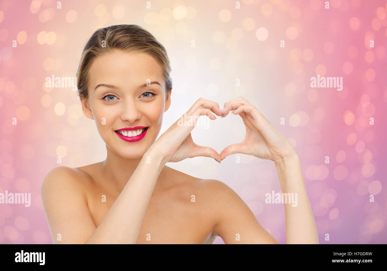 smiling young woman showing heart shape hand sign Stock Photo - Alamy