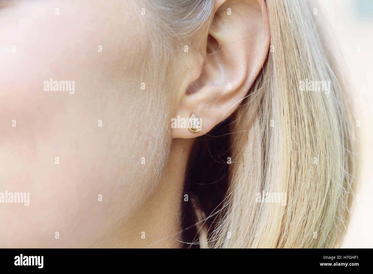 Woman's ear wearing an earring Stock Photo - Alamy