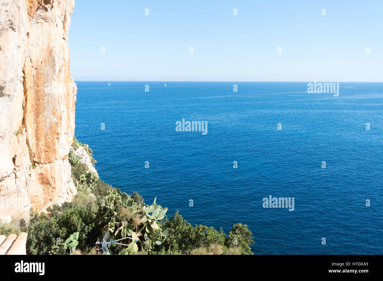 Sail boat and orange brown vertical rock near Cayanmel, Mallorca ...