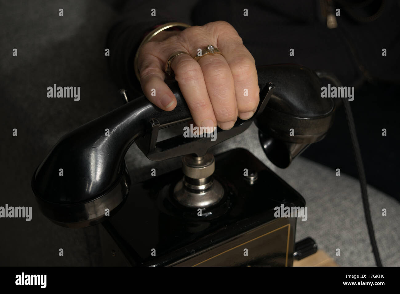 Grandma anticipating a call on the old black antique telephone Stock ...