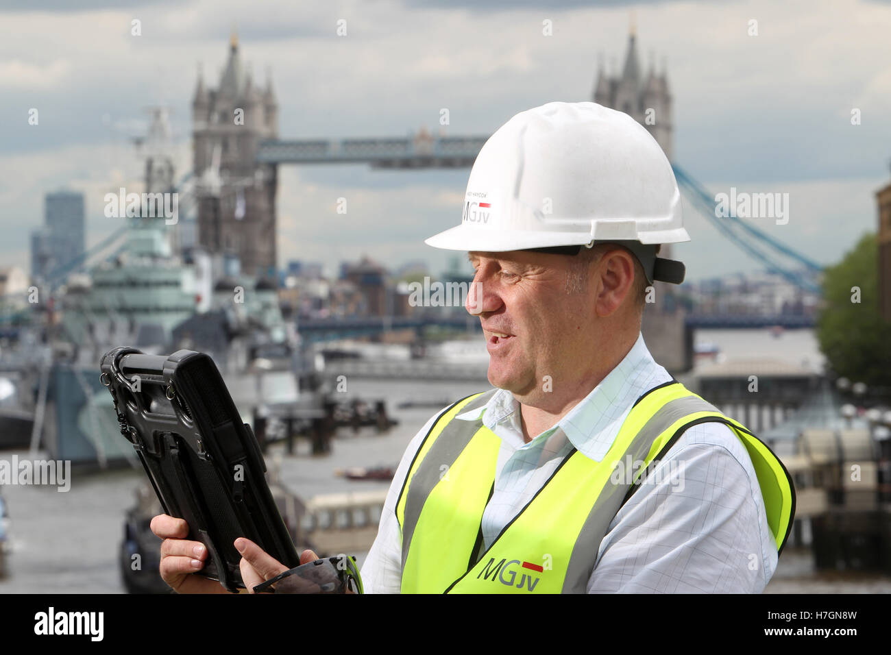 Worker with London bridge and aircraft carrier in background Stock ...