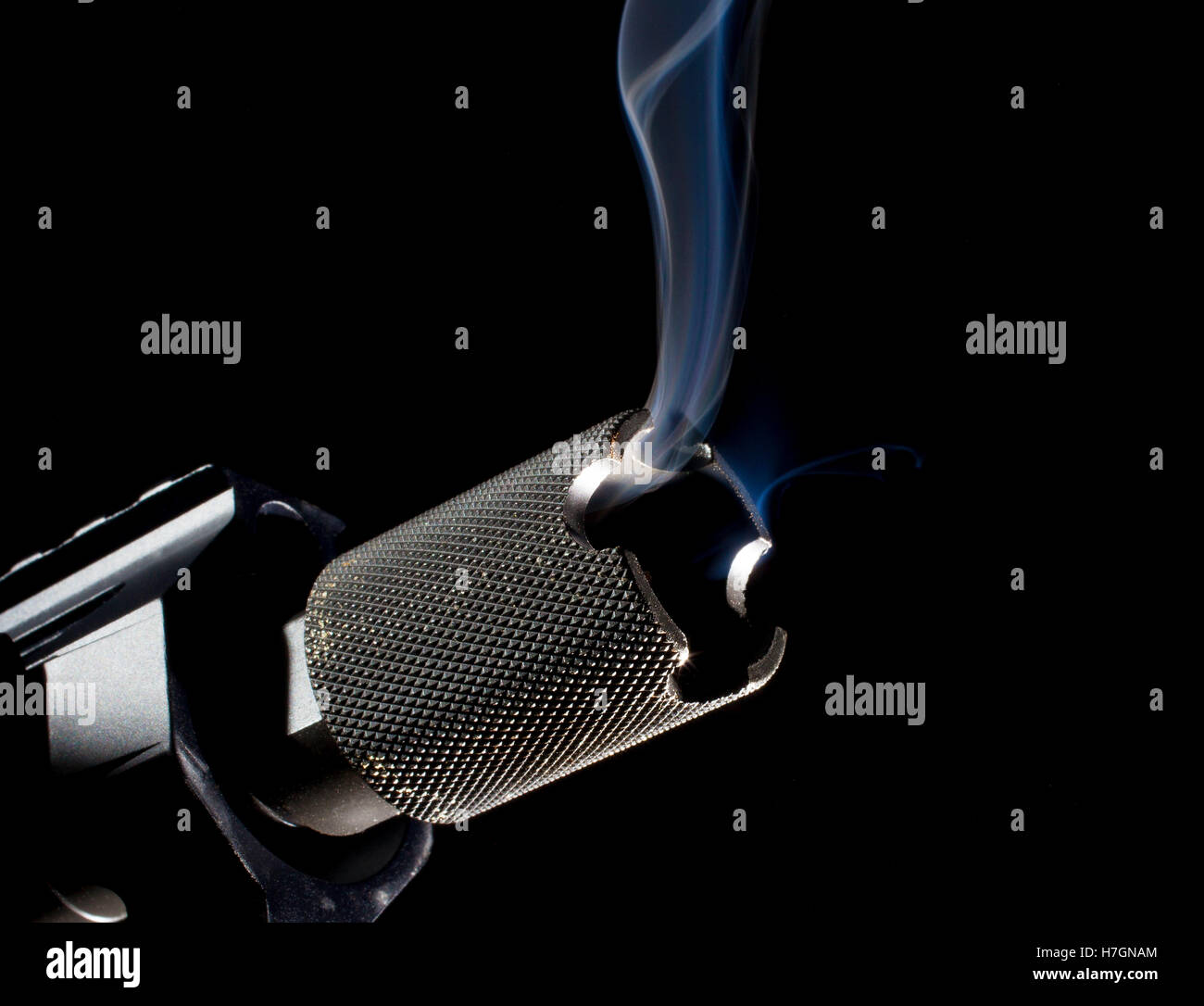 Muzzle end of a gun that is smoking on a black background Stock Photo ...