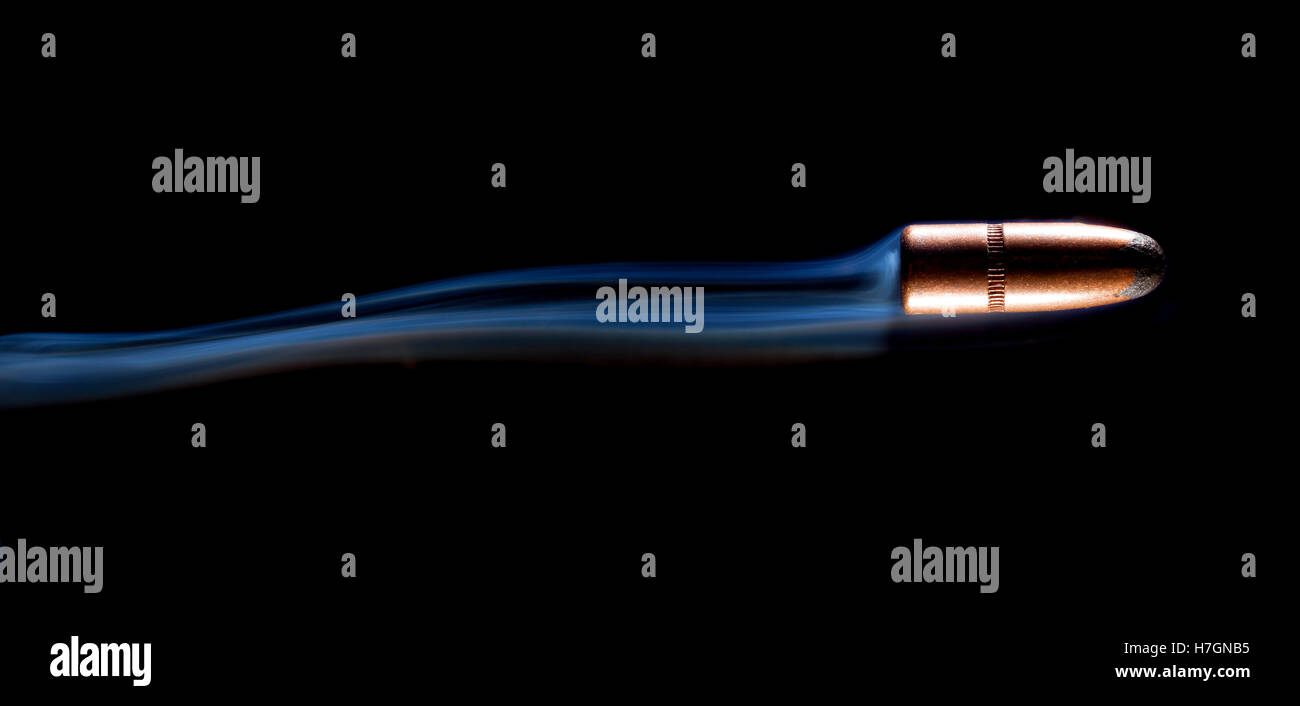 Copper colored lead core bullet with smoke on a black background Stock ...