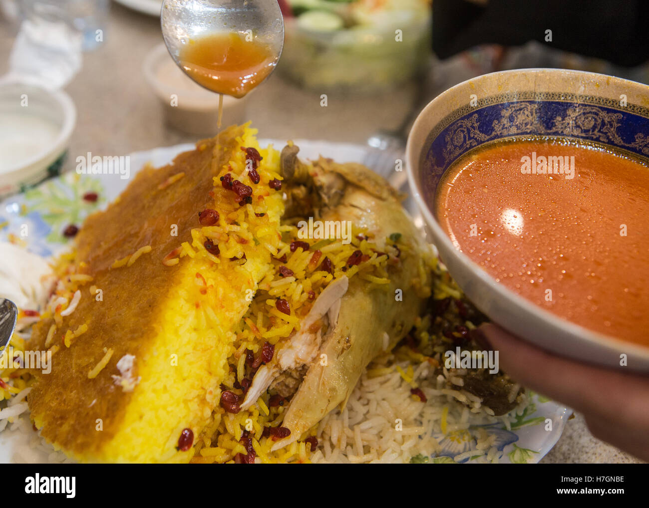 spooning juice over the tachin Stock Photo - Alamy