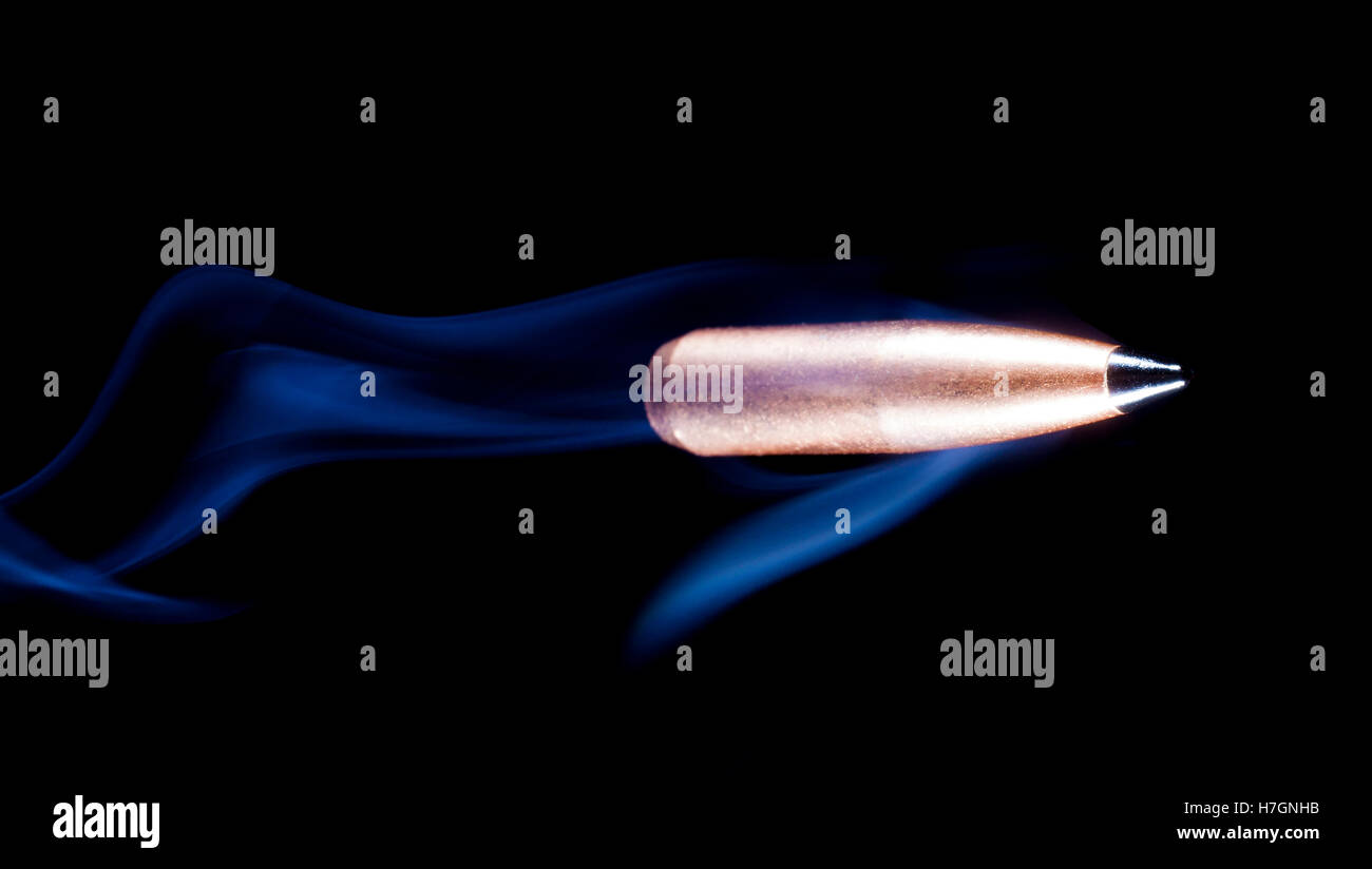 Blue smoke that is trailing behind a bullet with a black background ...