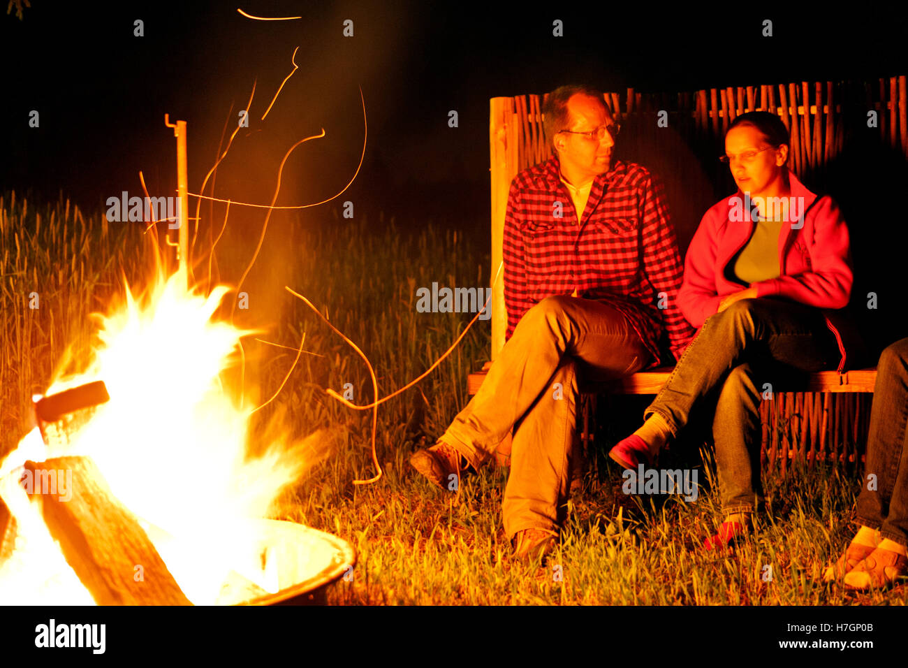 People sitting around campfire night hi-res stock photography and ...