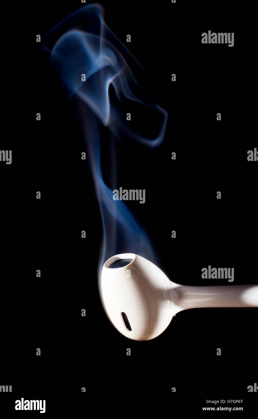 White earphone that is smoking on a black background Stock Photo - Alamy