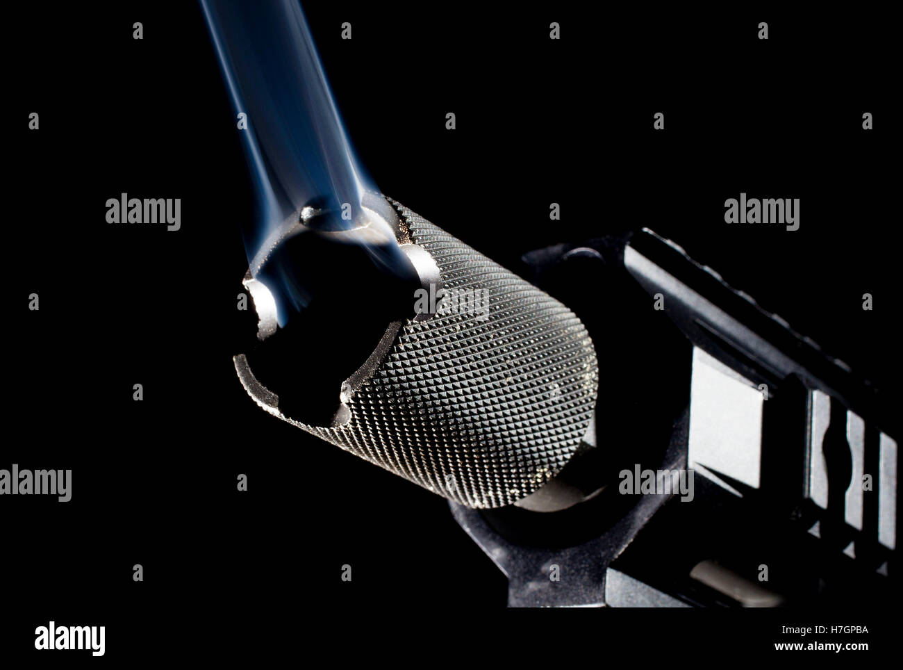 Gun barrel with smoke coming out on a black background Stock Photo - Alamy