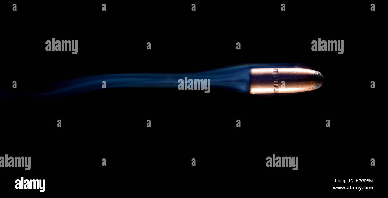 Copper plated bullet that looks fast with smoke behind on black Stock ...