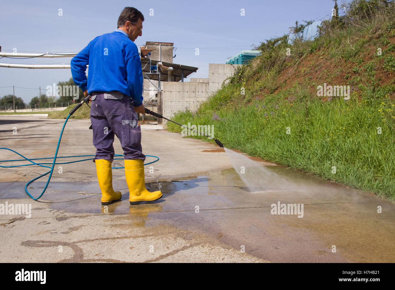 worker cleaning industrial site with a pressure washer Stock Photo - Alamy