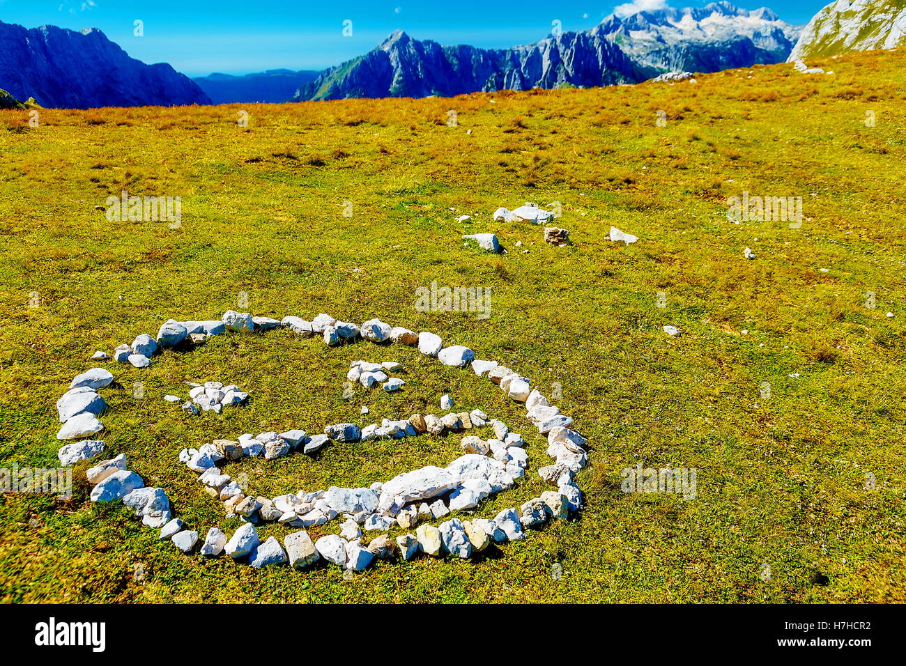 smiling face icon made of pebble stones on mountain meadow Stock Photo ...