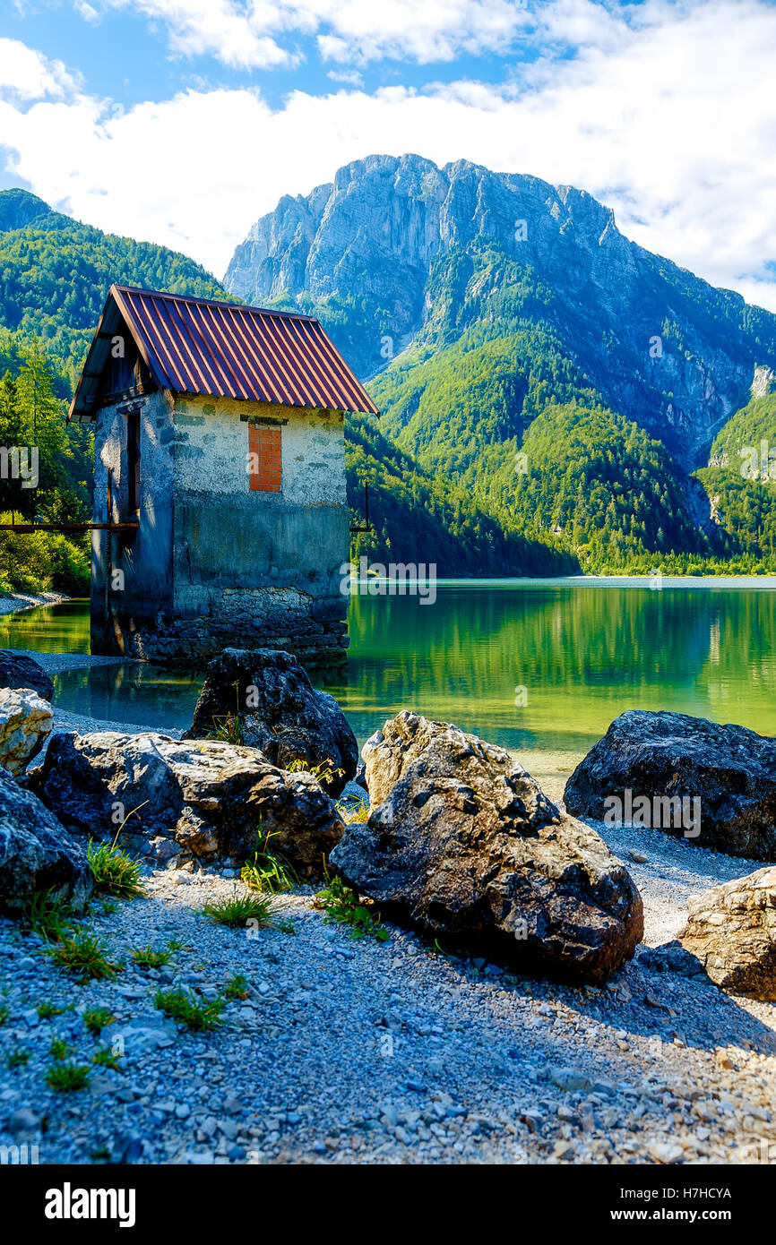 small building at a beautiful lake surrounded by stunning mountain ...