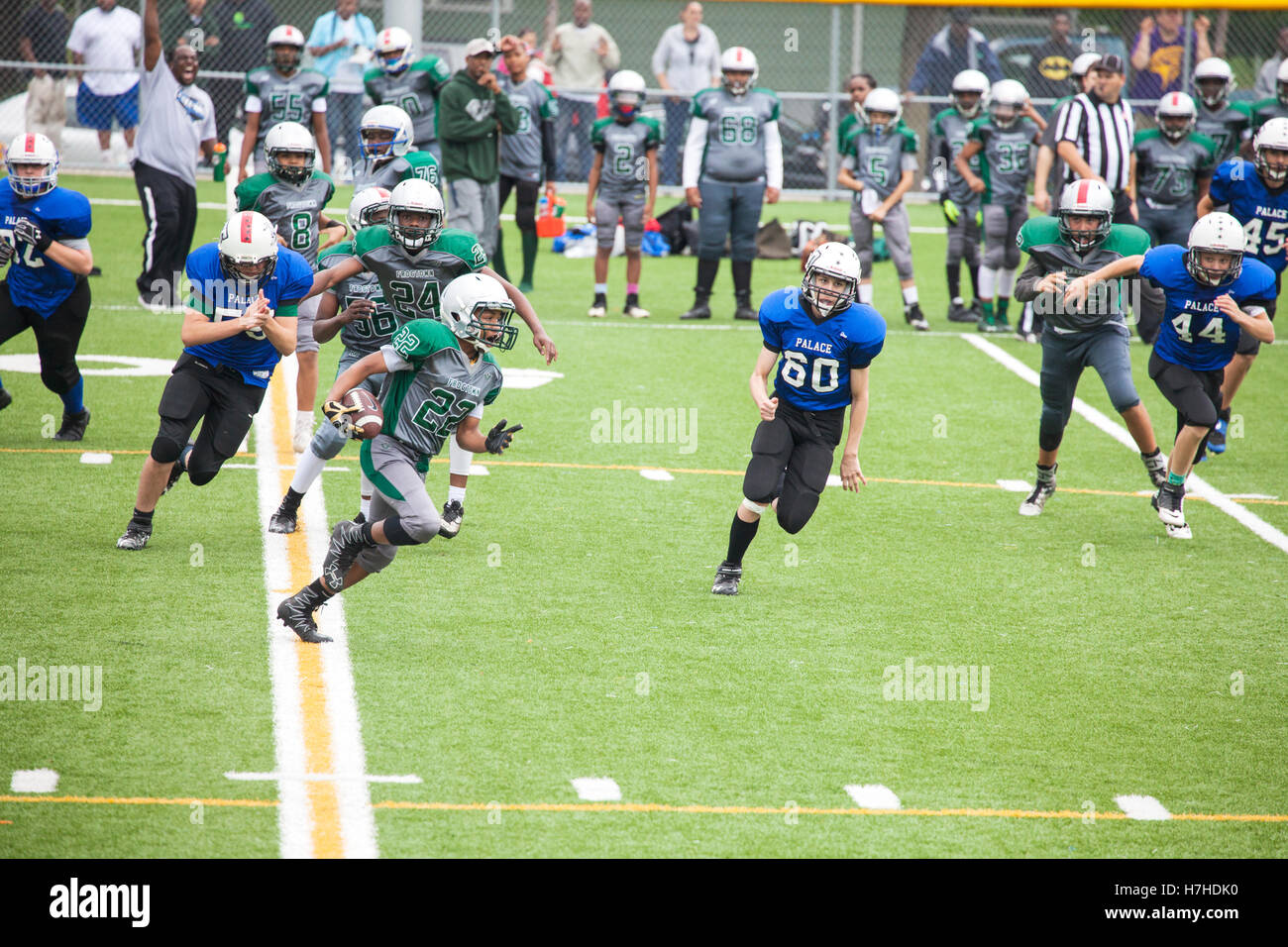 Young teen football game with runner making a sweep with opposition ...