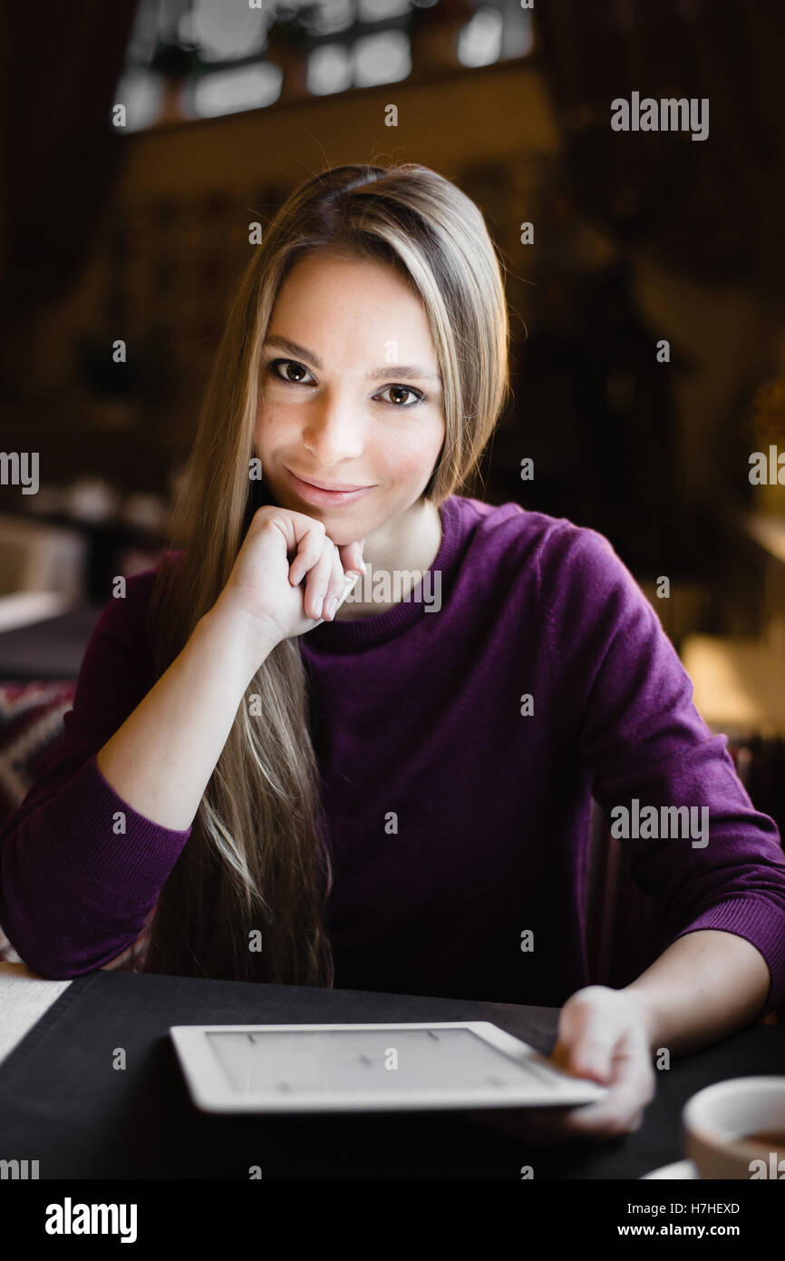 Woman holding tab looking at camera Stock Photo - Alamy