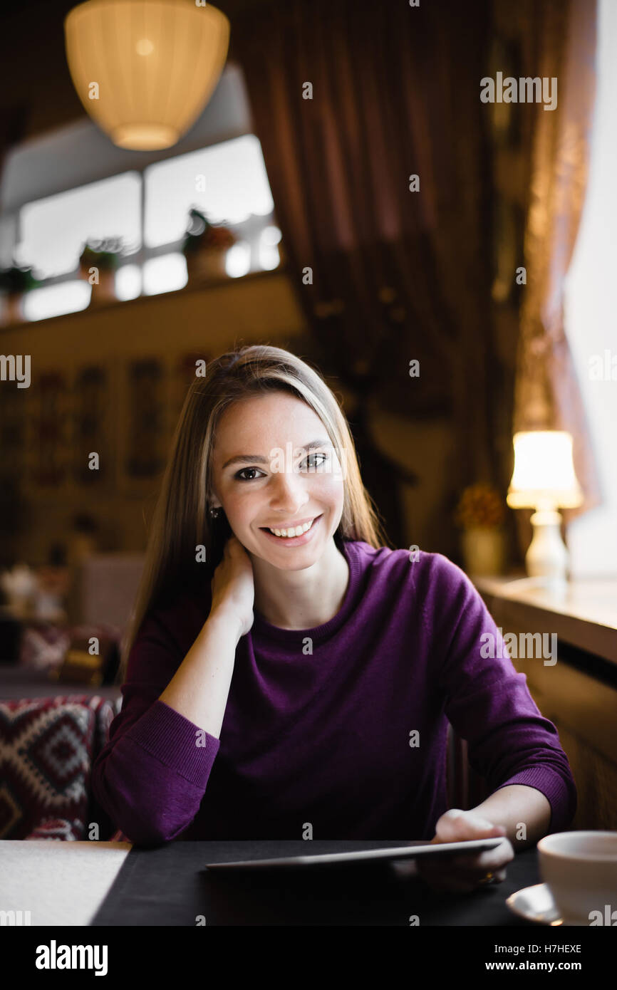 Smiling woman sitting with tab Stock Photo - Alamy