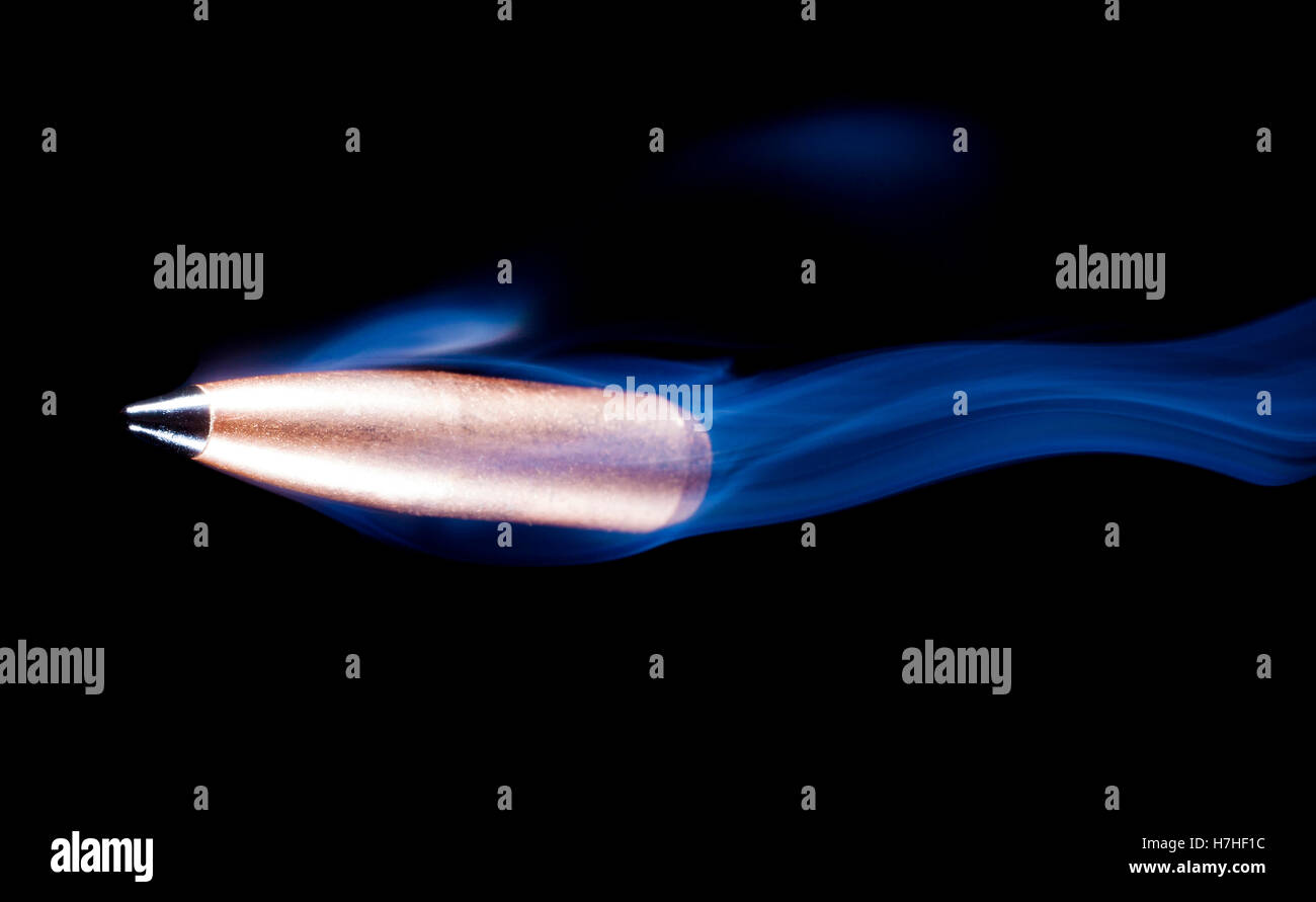 Copper coated bullet with a polymer tip and smoke behind Stock Photo ...