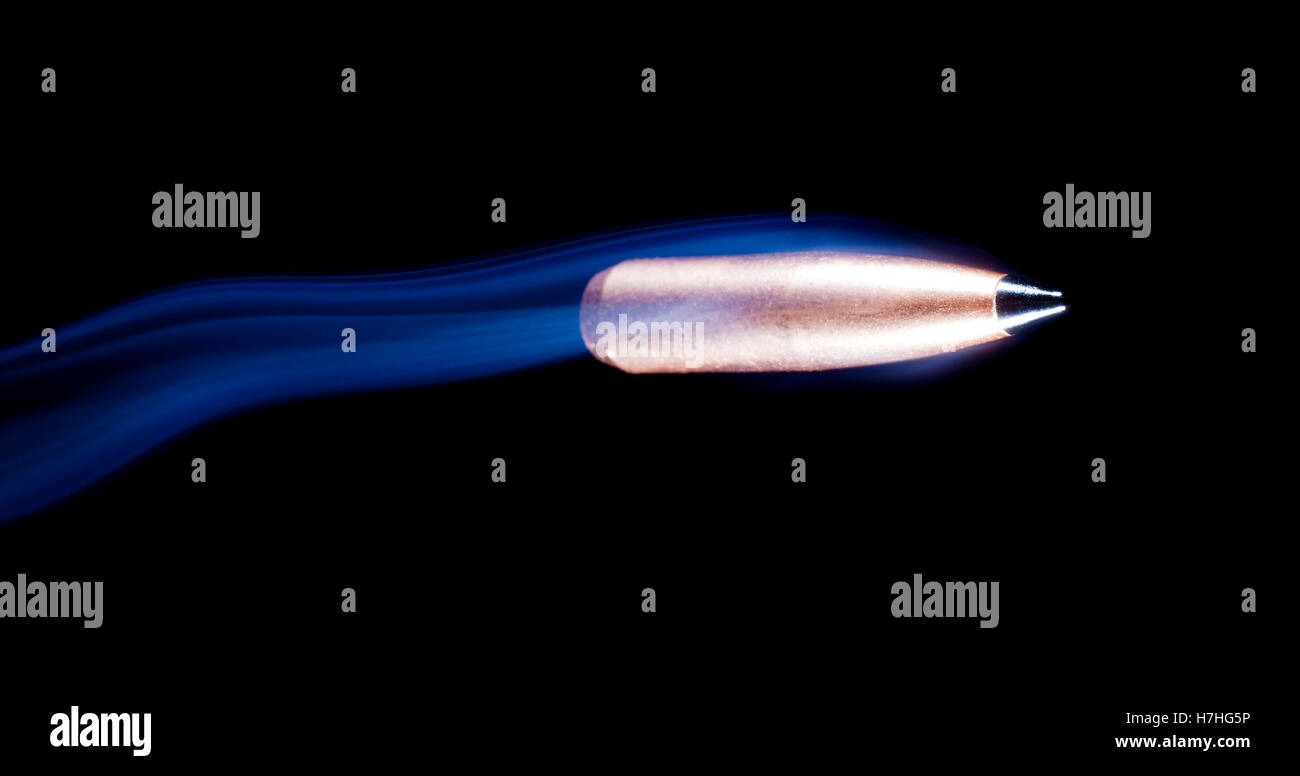 Bronze colored bullet with smoke behind on a black background Stock ...