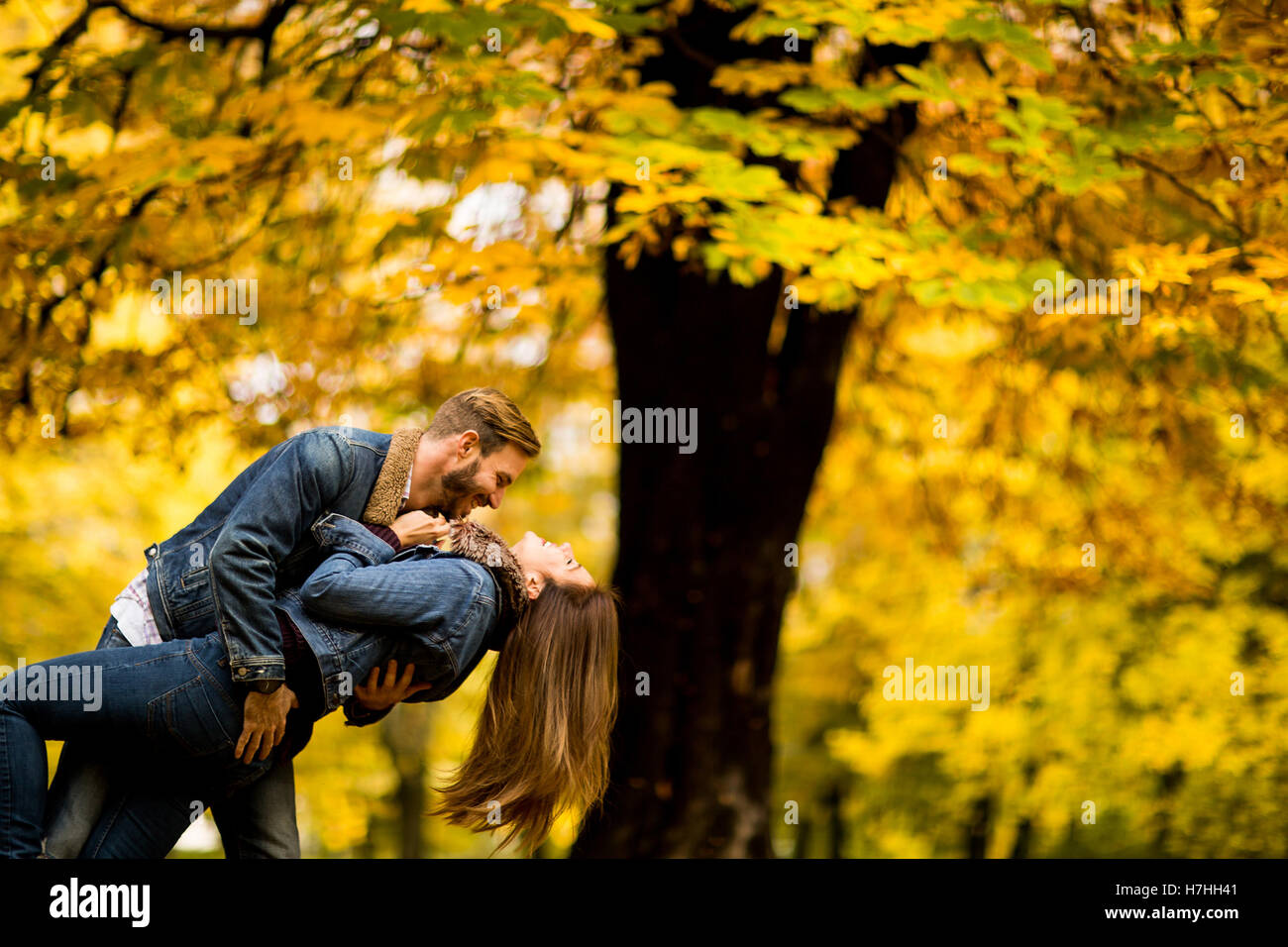 Young couple having fun in the autumn park Stock Photo - Alamy