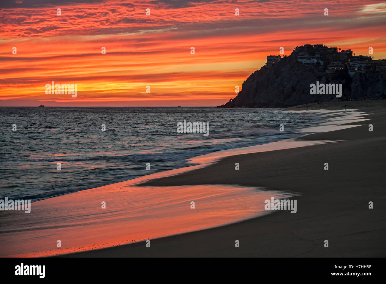 Orange clouds, silhouette of rocky cliff and beach, Solmar Beach, Cabo ...