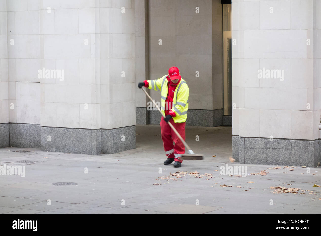 Workman sweeping leaves in St Paul's Churchyard, City of London, UK ...