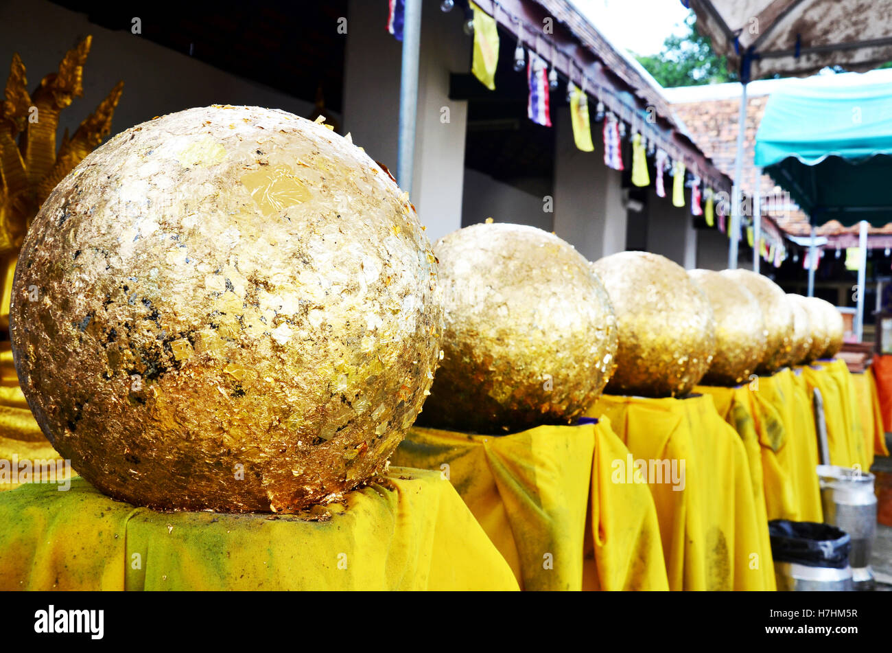 Thai people cover the sacred marker spheres with thin gold leaves on ...