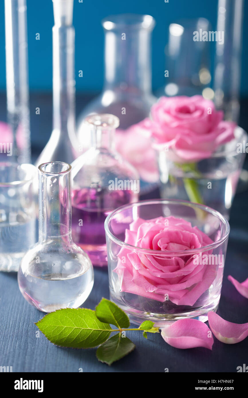 alchemy and aromatherapy set with rose flowers and chemical flasks ...