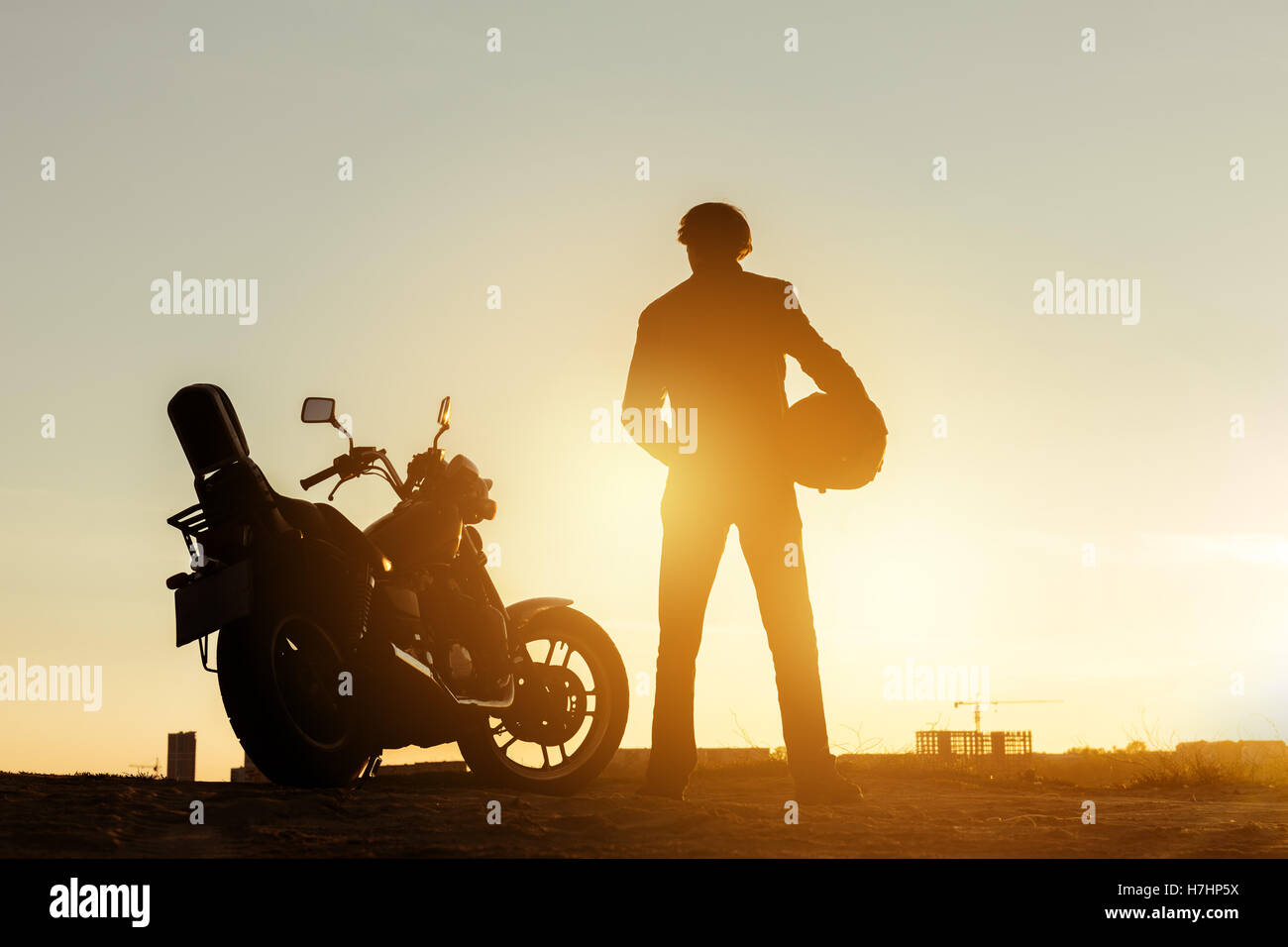 Biker with motorcycle at sunset time Stock Photo - Alamy