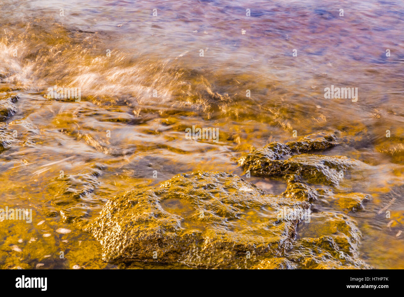 rock emerging from the water Stock Photo - Alamy