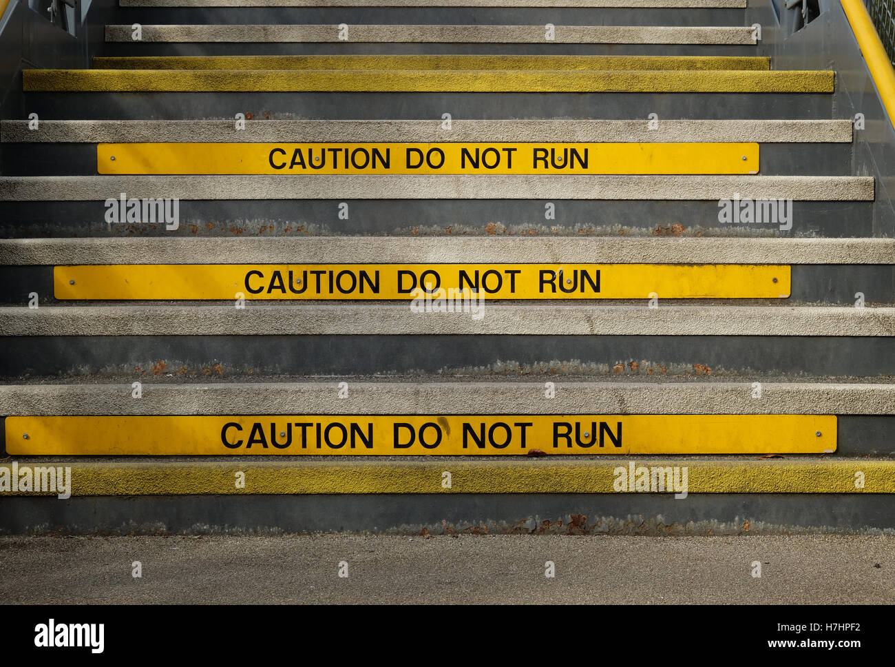 steps on a metal bridge with caution signs Stock Photo - Alamy