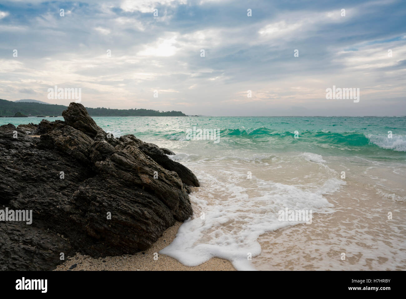 The Rock on the sand beach with wave of the sea and sky at the ...