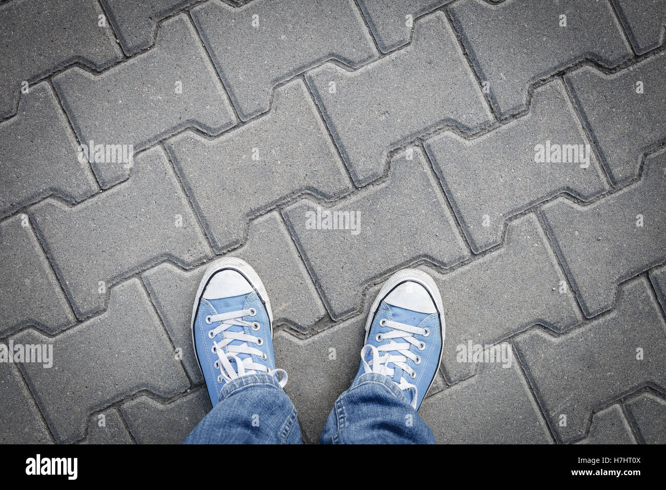 On a walk - wearing sneakers, top view on concrete pavement and blue ...