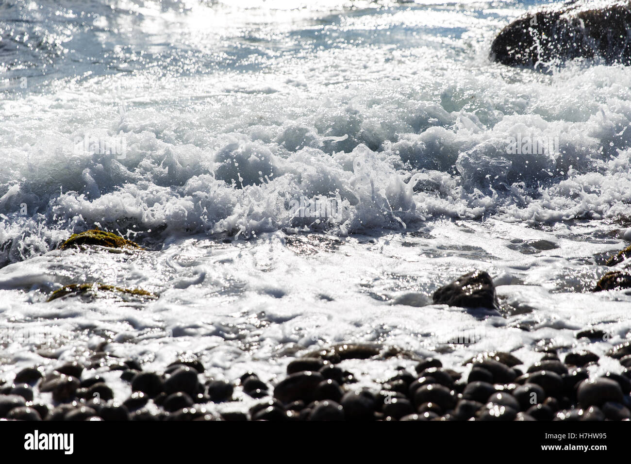 Pebble beach with small waves Stock Photo - Alamy