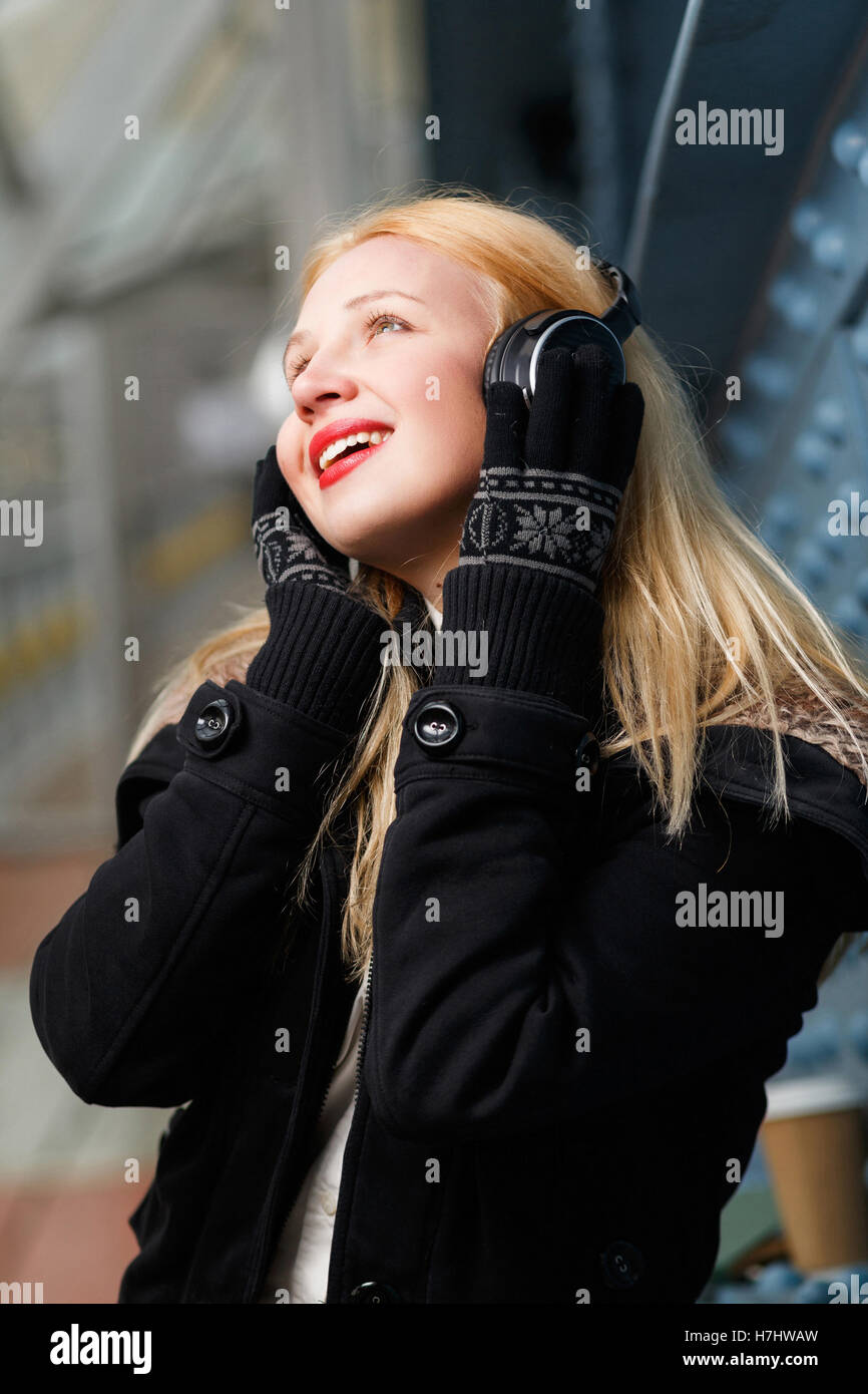 Beautiful ginger lady enjoys listening music in headphones Stock Photo ...