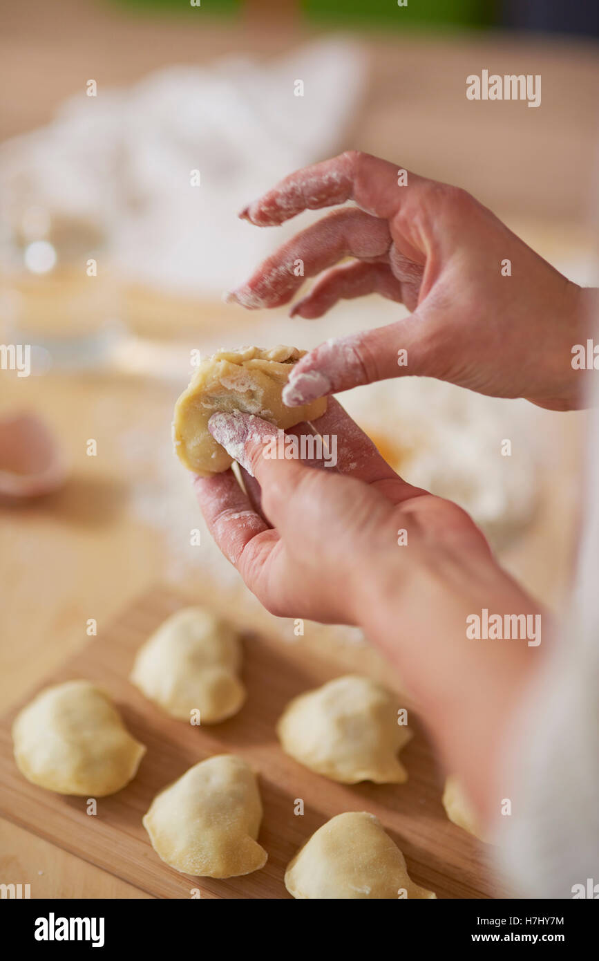 Woman closing dumpling with traditional filling Stock Photo - Alamy