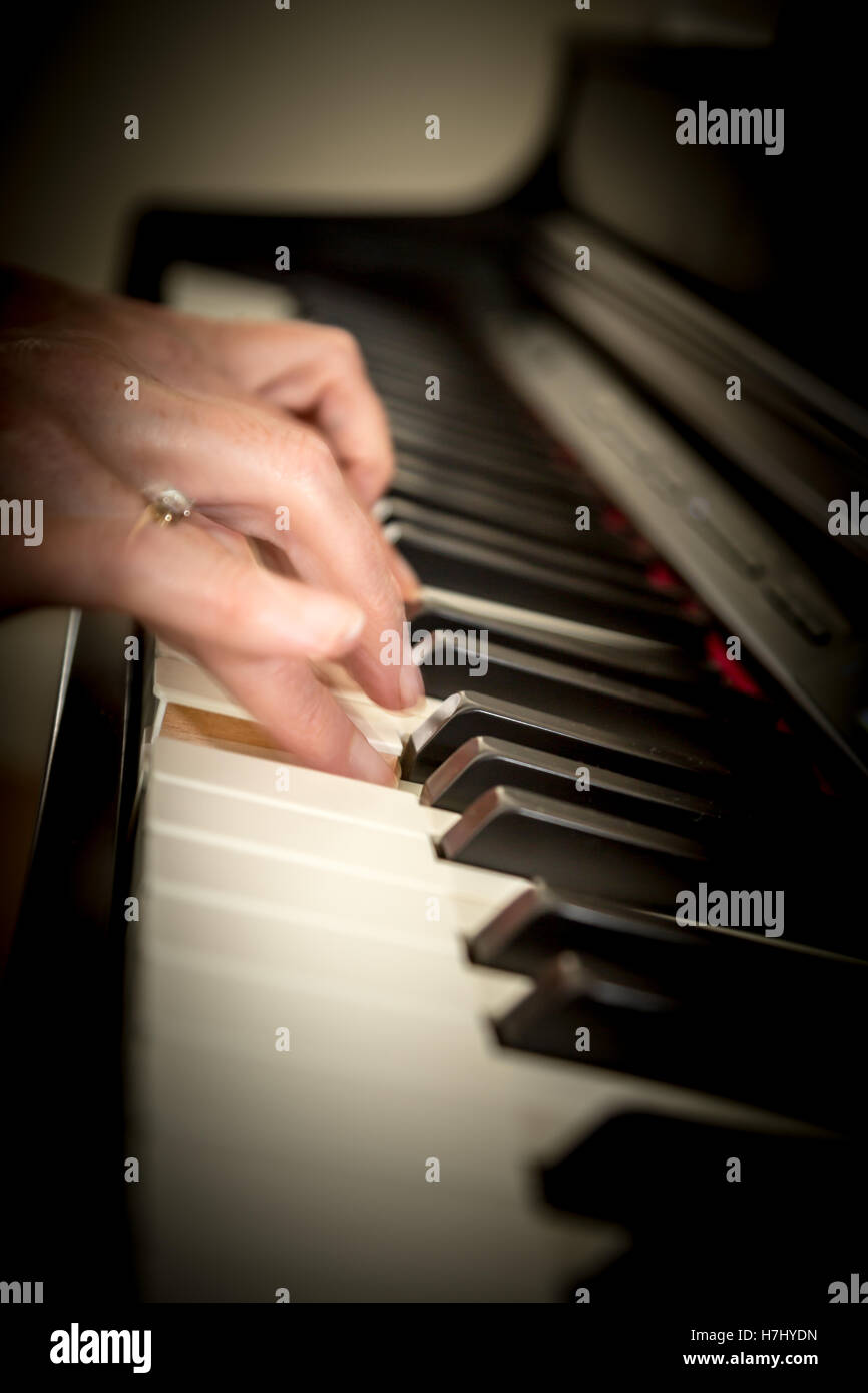 Woman playing a piano keyboard Stock Photo - Alamy