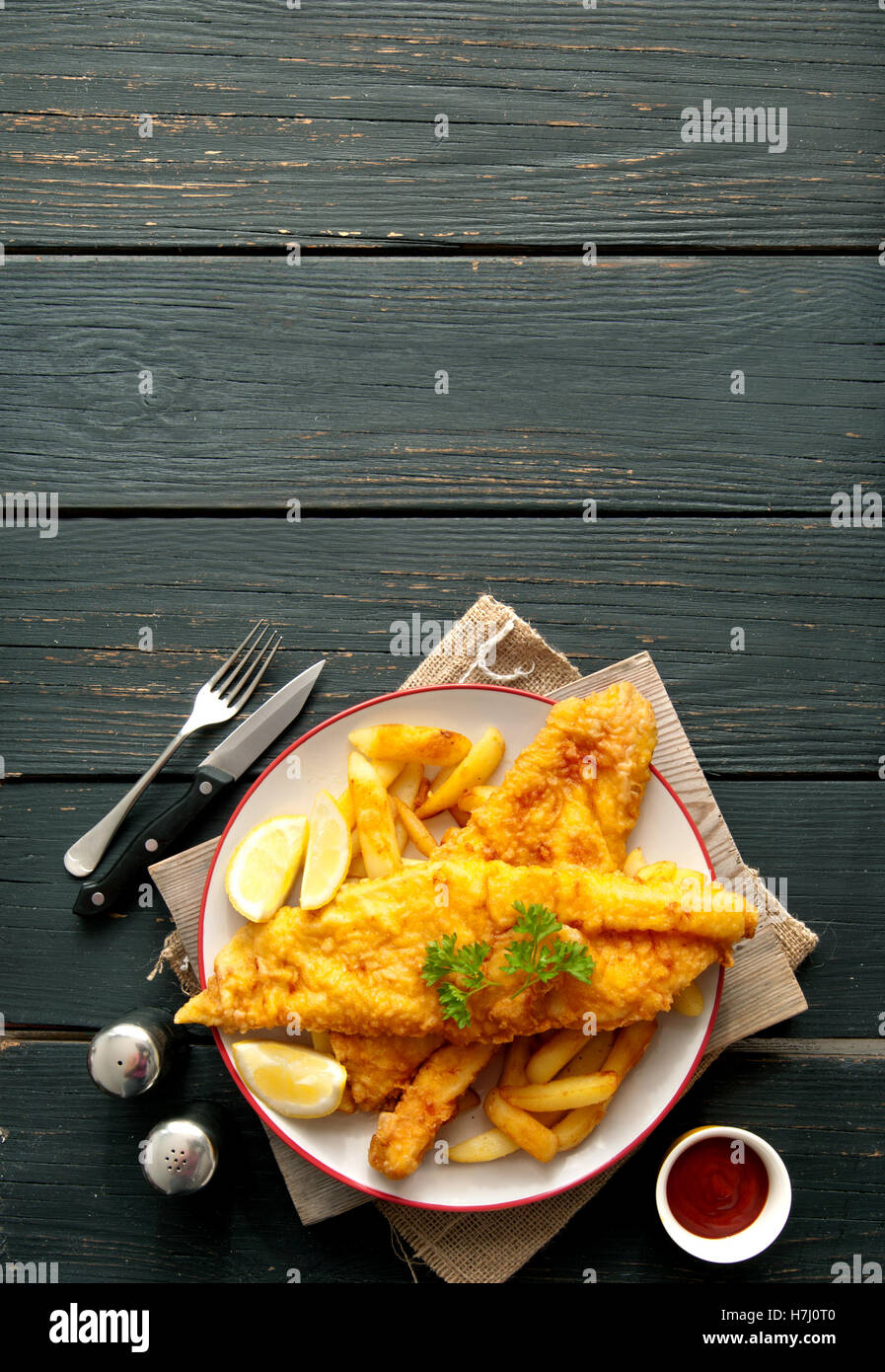 Two pieces of battered fish on a plate with chips with space Stock ...