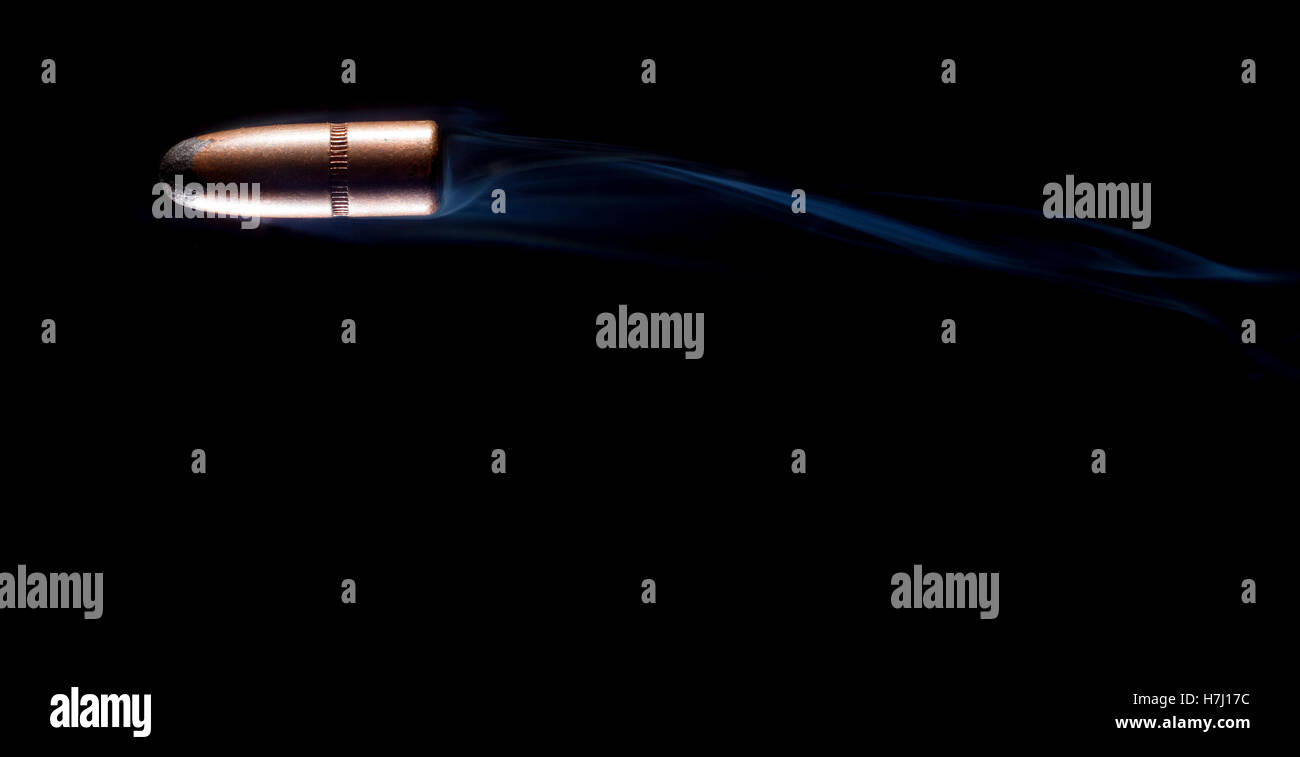 Copper plated bullet with smoke trailing on a black background Stock ...