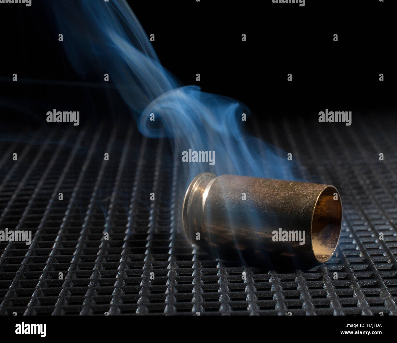 Smoke rising around an empty casing from a handgun cartridge Stock ...