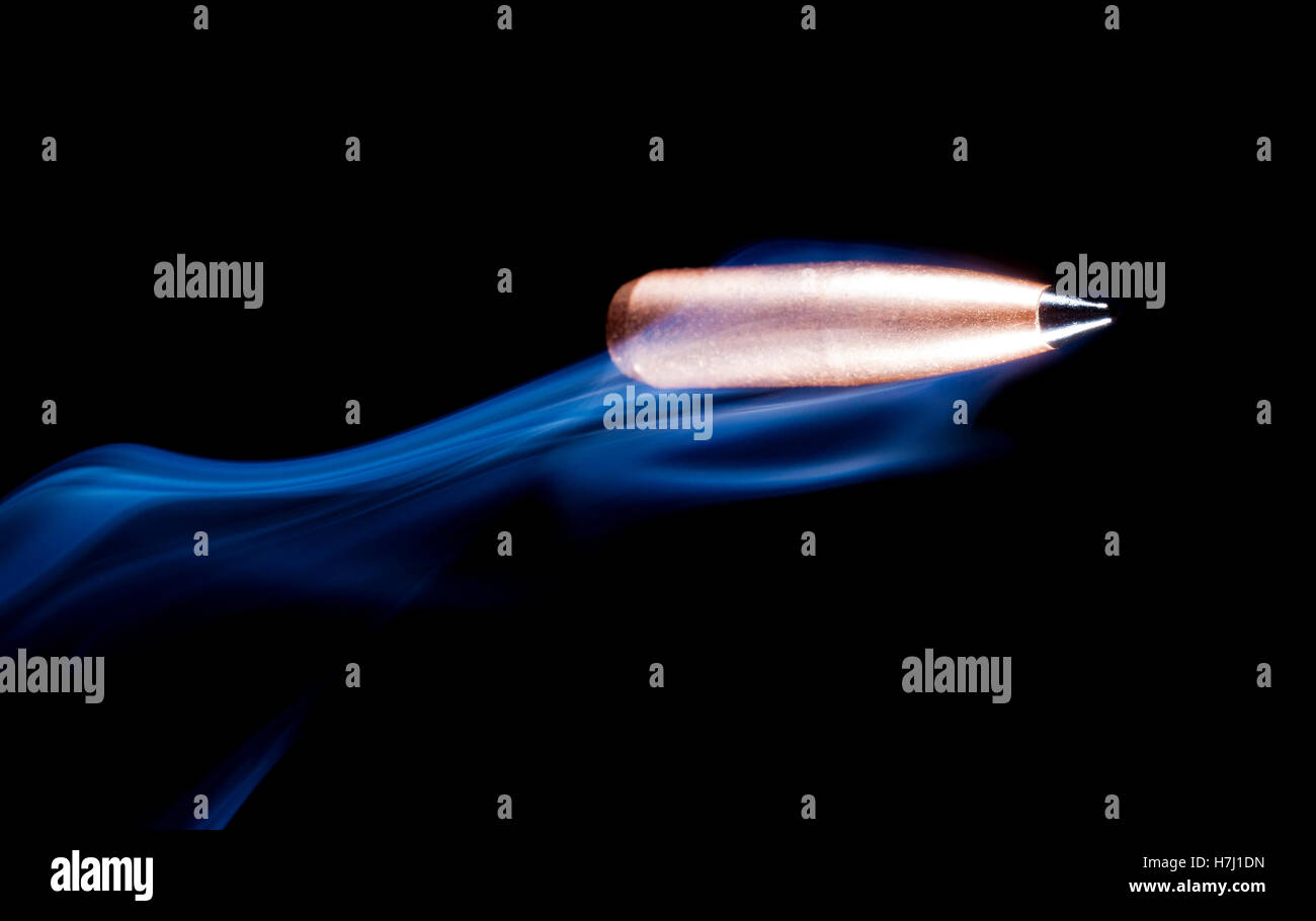 Polymer tipped bullet with copper coating on a black background with ...