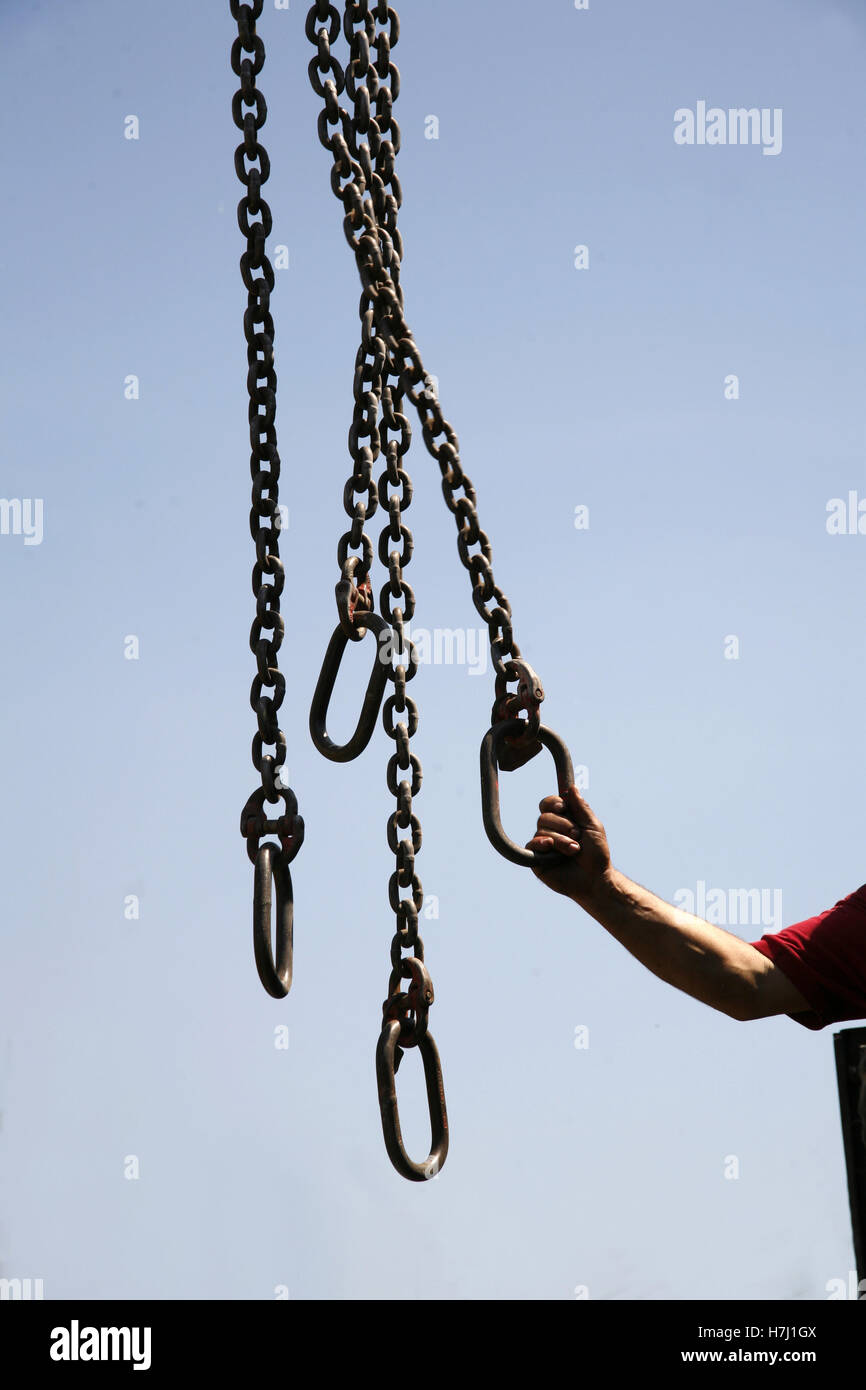 Long rusty chains with crane hook as industrial background. Hand of ...
