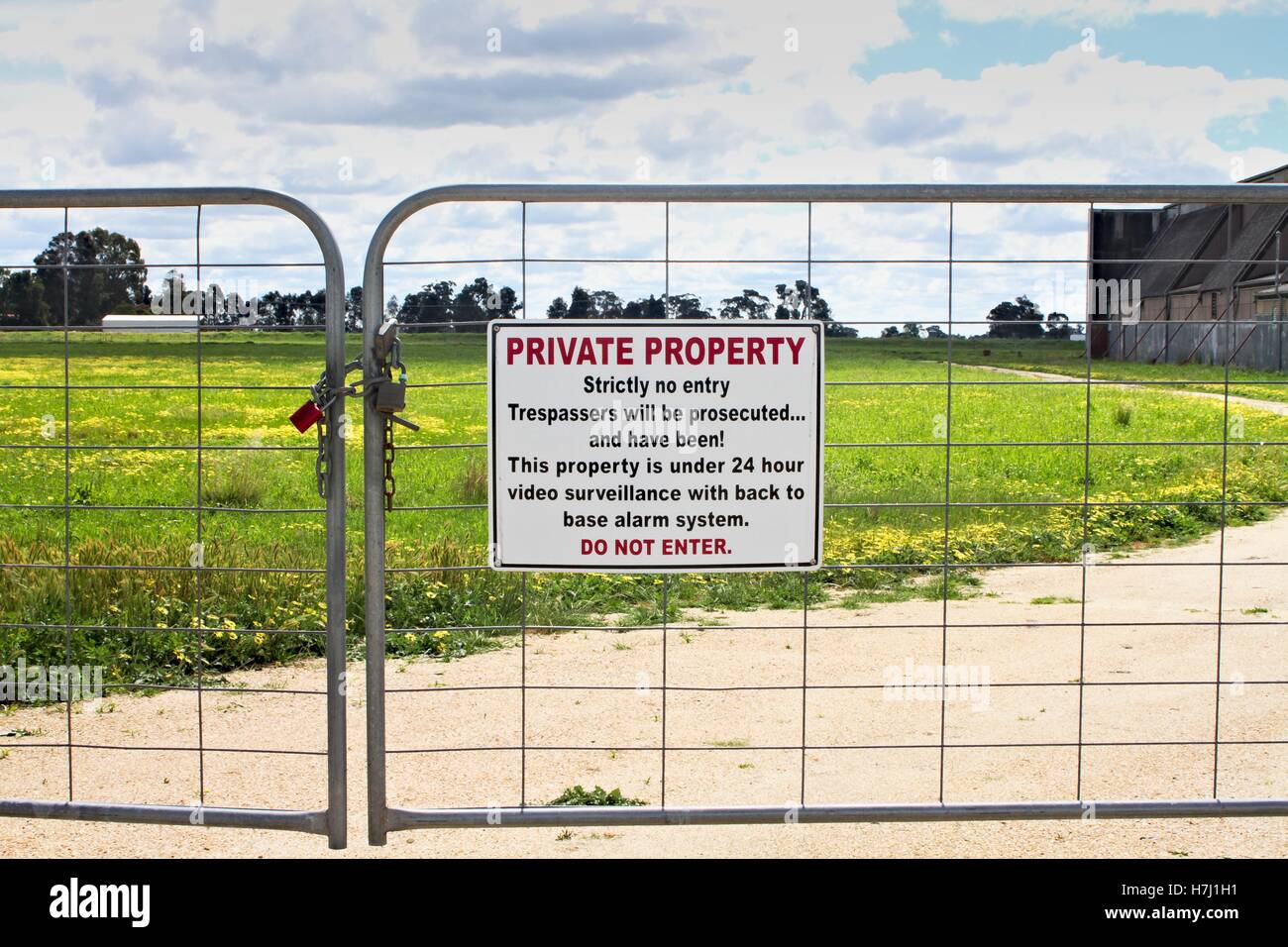 Private property sign on metal gate, with paddock and historic airplane ...