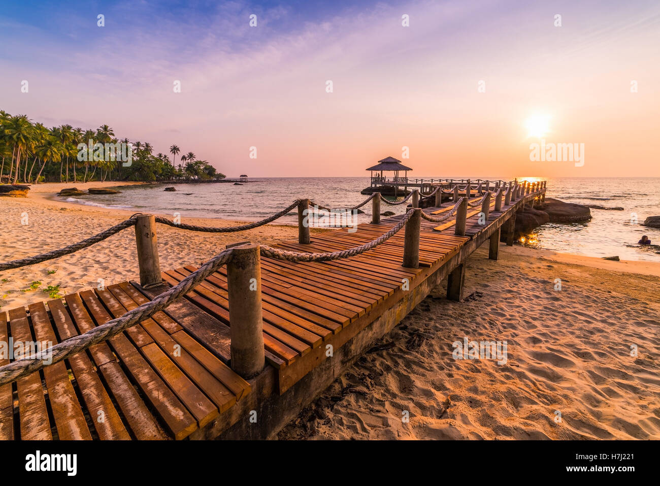 Long wooden bridge pavilion in beautiful tropical island beach sunset ...