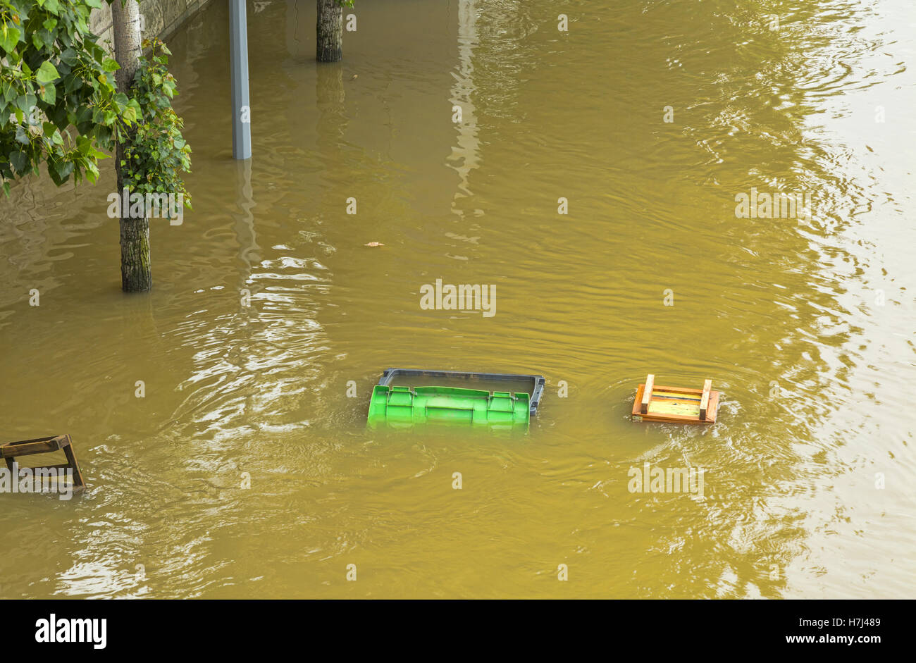 A garbage container and various wooden things are floating on the River ...