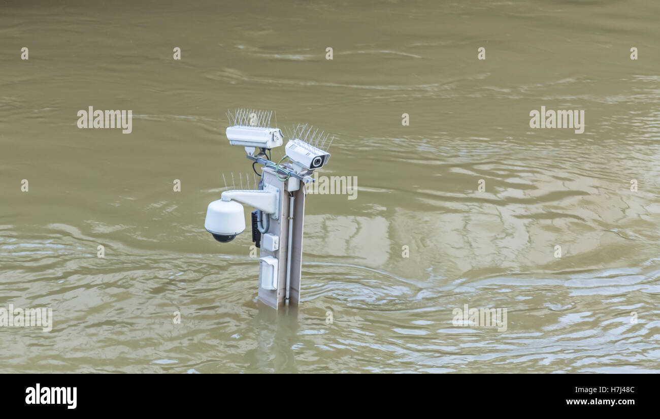 Surveillance cameras on the top of a pole are almost covered by water ...