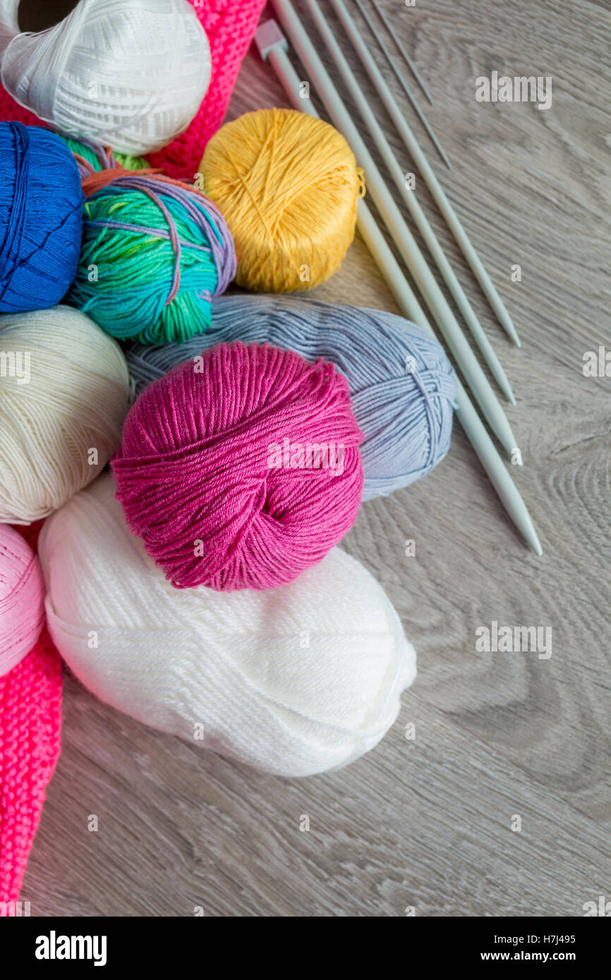 Knitting. Group of yarn and needles on grey wooden table a. Handmade ...