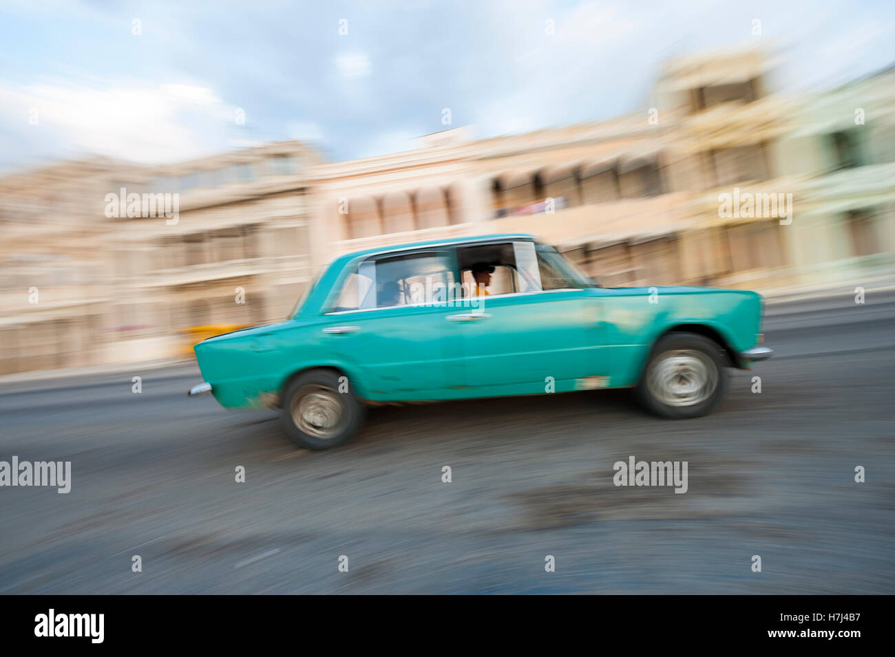 Vintage taxi driving in front of classic colonial architecture on the ...