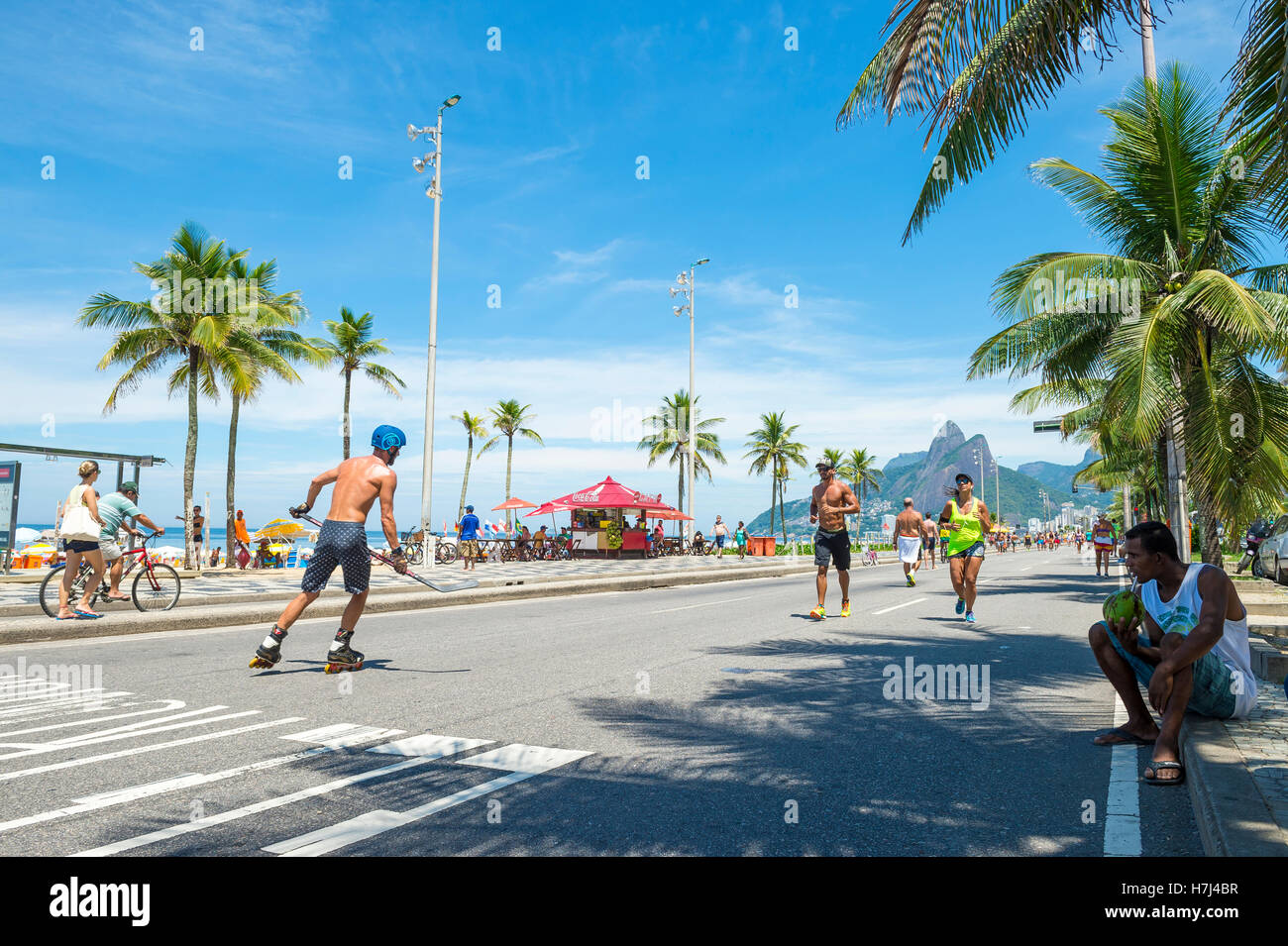 RIO DE JANEIRO - FEBRUARY 28, 2016: Beachgoers stroll with active ...