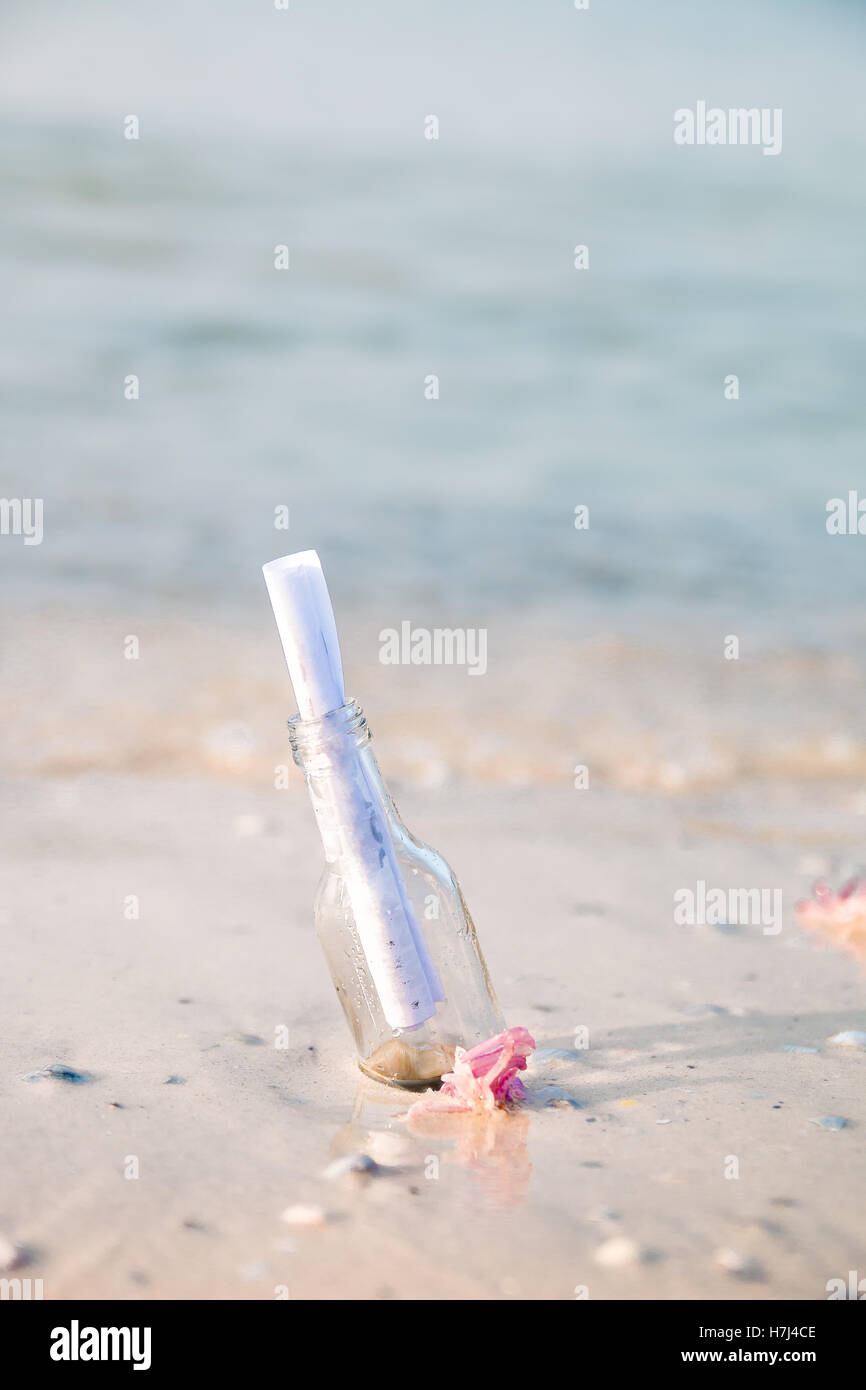 Bottle with a message or letter on the beach near seashell. SOS Stock ...