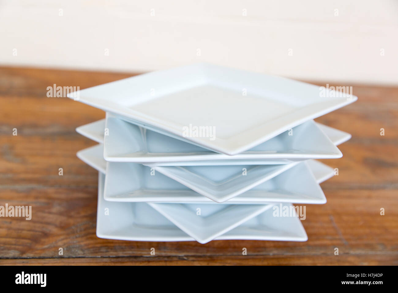 A stack of white square plates Stock Photo - Alamy