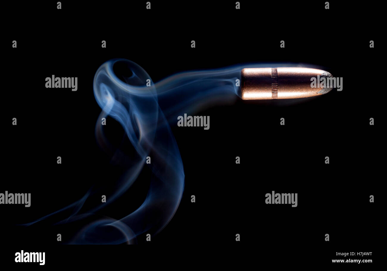 Copper coated lead bullet with smoke on a black background Stock Photo ...
